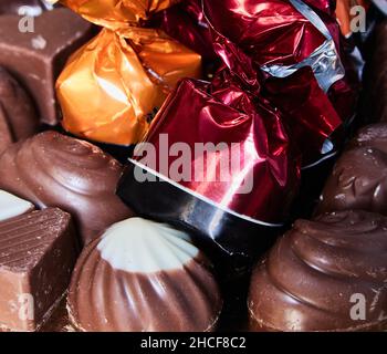 Chocolates wrapped in foil in luxury candy. Chocolate candies in a box ...