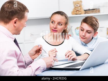 Mother and son signing documents Stock Photo - Alamy