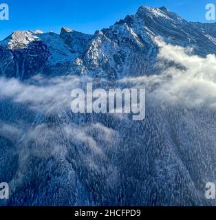 Aerial view of mountain peaks coming out through the clouds Stock Photo ...