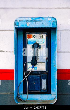 A coin-operated public telephone also called a payphone, hangs on the ...