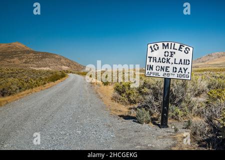 Desert road with rough road sign and distant red cliffs under a clear ...