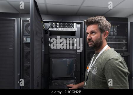 Data Center Engineer Usaing Keyboard on a Supercomputer Server Room ...