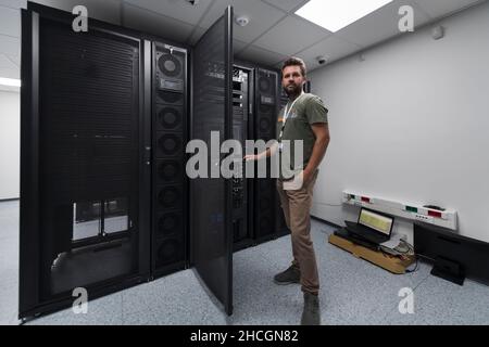 Data Center Engineer Usaing Keyboard on a Supercomputer Server Room ...