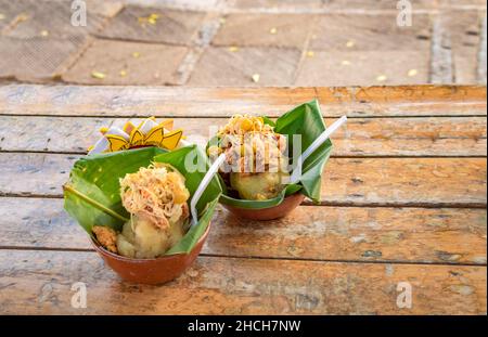 Vigoron with leaves served on a wooden table, two vigorones served on ...