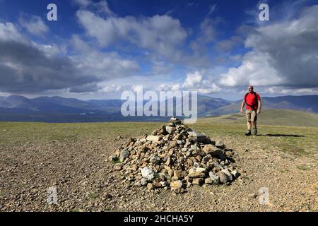 Walker at the summit of Great Dodd fell above St Johns in the Vale ...