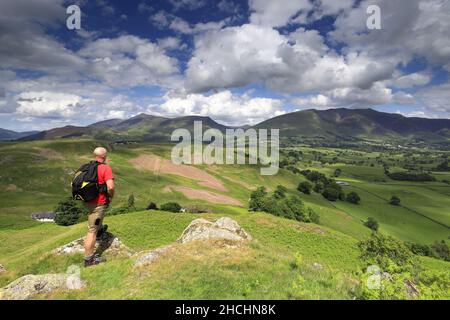 Walker at the summit cairn of High Rigg fell overlooking St Johns in ...