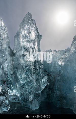 A photo of a backlit iceberg showing clear, blue and black ice with ...