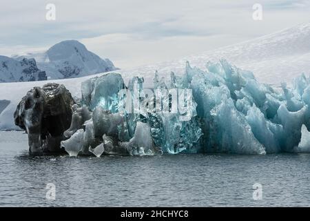 A photo of a backlit iceberg showing clear, blue and black ice with ...