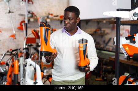 Man chooses rubber boots at garden supply store Stock Photo - Alamy