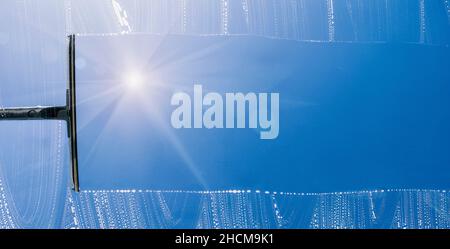 Rubber squeegee cleans a soaped window Stock Photo - Alamy