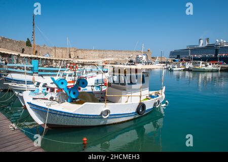 Fishing boats docked in Rhodes Harbor, Greece with medieval walls in ...