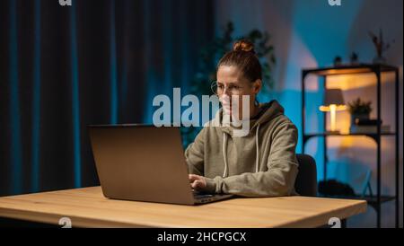 Focused professional woman working late in contemporary office space ...