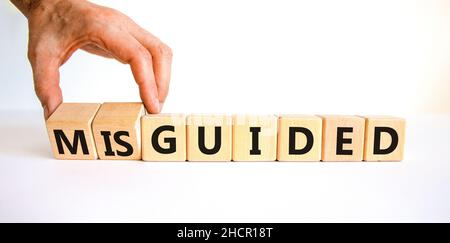 Guided or misguided symbol. Businessman turns wooden cubes and changes ...