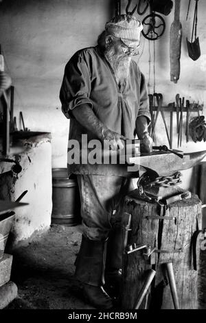 A blacksmith demonstrates his trade in the blacksmith shop at El Rancho ...