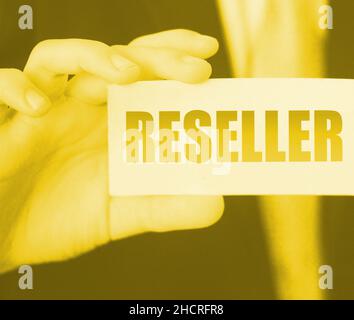 Businessman holding a card with Reseller word. Reselling business ...