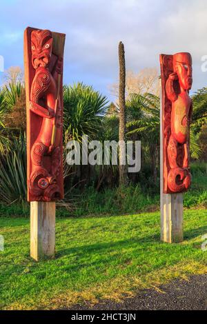 Maori traditional carved wooden pou or guardian outside a marae in New ...