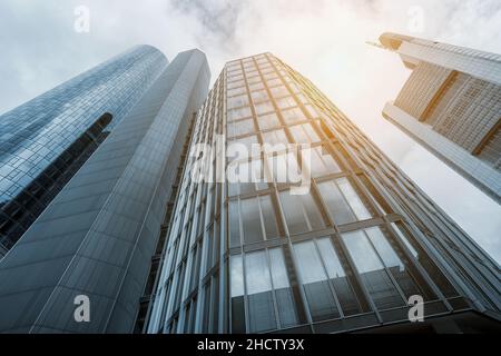 Bottom view of modern skyscrapers in business district against blue sky ...
