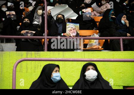 A woman holds posters of the Iranian former Islamic Revolutionary Guard ...
