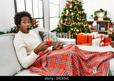 Confused african american guy drinking coffee and holding copyspace ...