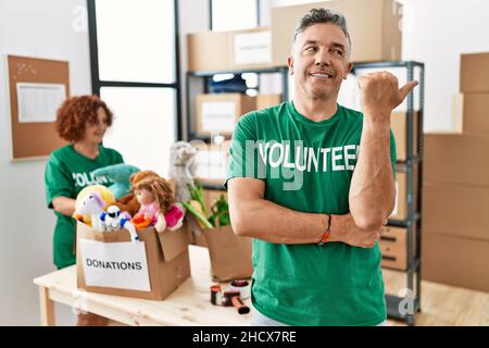 Middle age man wearing volunteer t shirt working with laptop relaxed ...