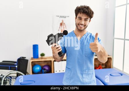 Hispanic physiotherapy man working at pain recovery clinic smiling ...