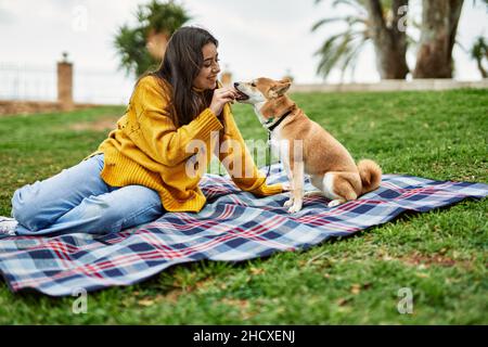 Beautiful young woman training shiba inu dog at park Stock Photo - Alamy