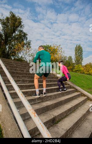Two amazing and attractive fit friends are warming up together and ...