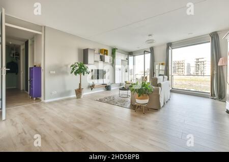 Comfortable sofa with cushions placed against light wall with TV and ...