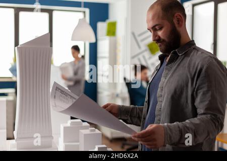 Architect standing near desk with blueprints Stock Photo - Alamy