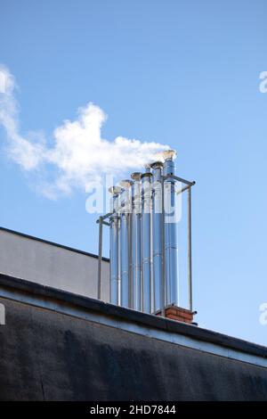 Natural gas exhaust floating above the chimneys of an apartment ...