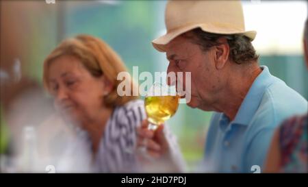 Older man drinking beer, candid senior drinks draft beer at restaurant ...