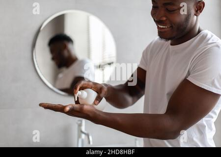Black Guy Using Liquid Soap From Bottle Applying It On Hand Before ...