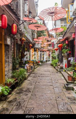 FENGHUANG, CHINA - AUGUST 15, 2018: Narrow alley with umbrellas and ...