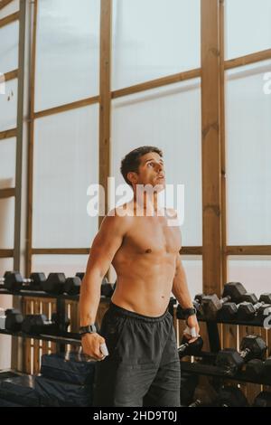 Young Spanish muscular male athlete training with kettlebells. The ...