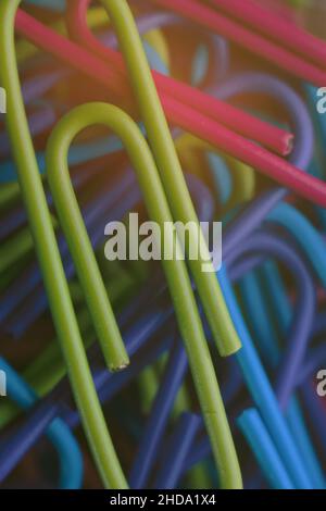 Vertical shot of colorful paper clips and adhesive tapes in a wooden ...