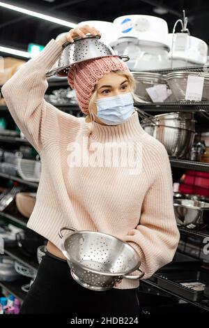 A woman wearing a colander as a hat Stock Photo - Alamy