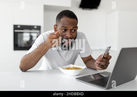 Black man rushing to work eating cereal at home Stock Photo - Alamy