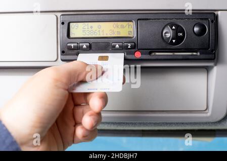 Digital tachograph and drivers hand inserting drivers card in it. No ...