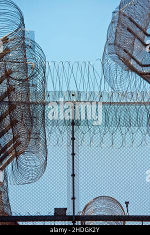 Security lookout tower and razor wire topped wall at Robben Island ...