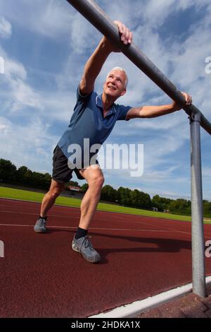 Low angle view of positive sportsmen with basketball ball looking at ...
