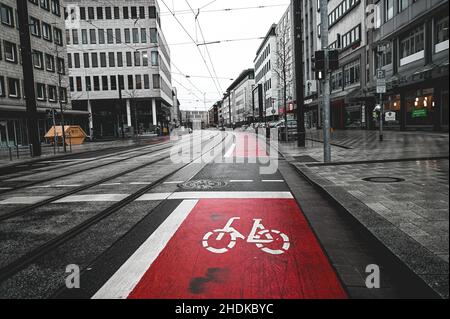 A red bicycle path with a white bicycle printed on it in Hannover at ...