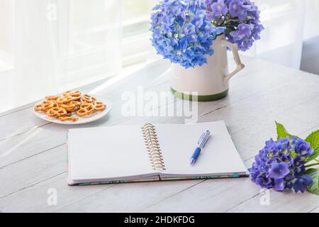 Hydrangea flowers with notebook on the table with copy space for text ...