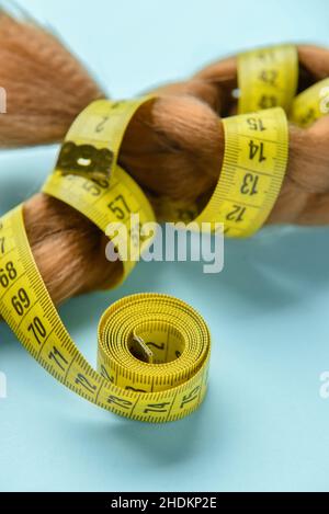 Braided red hair for donation with measuring tape on white background ...