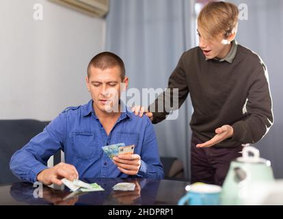 Father gives pocket money to his teenage son. Son thanks father Stock ...