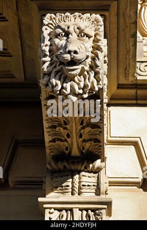 Ancient stone relief of a lion's head, carved into a wall, rich in ...