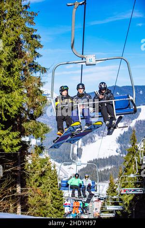 BUKOVEL, UKRAINE - February 10, 2019: people at ski lift in mountains ...