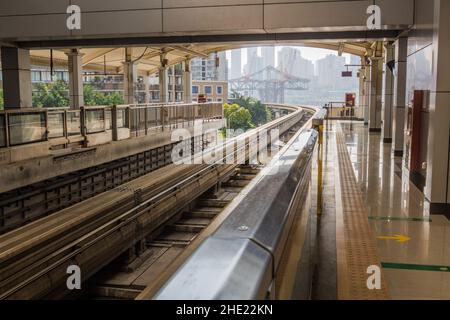 A monorail train of Chongqing Light Rail Line passes through a glass ...