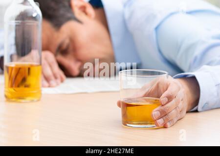 A drunk businessman / office worker sleeping at his computer keyboard ...