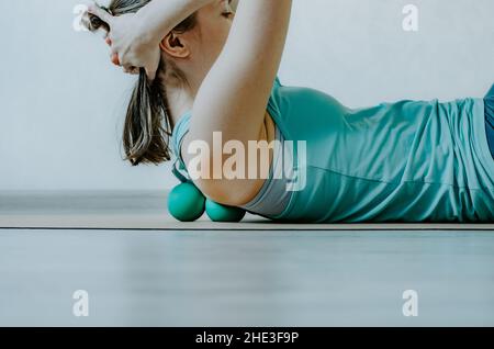 Woman doing back muscles myofascial release with two therapy massage ...