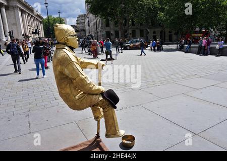 Street performer Golden man floating on air Stock Photo - Alamy